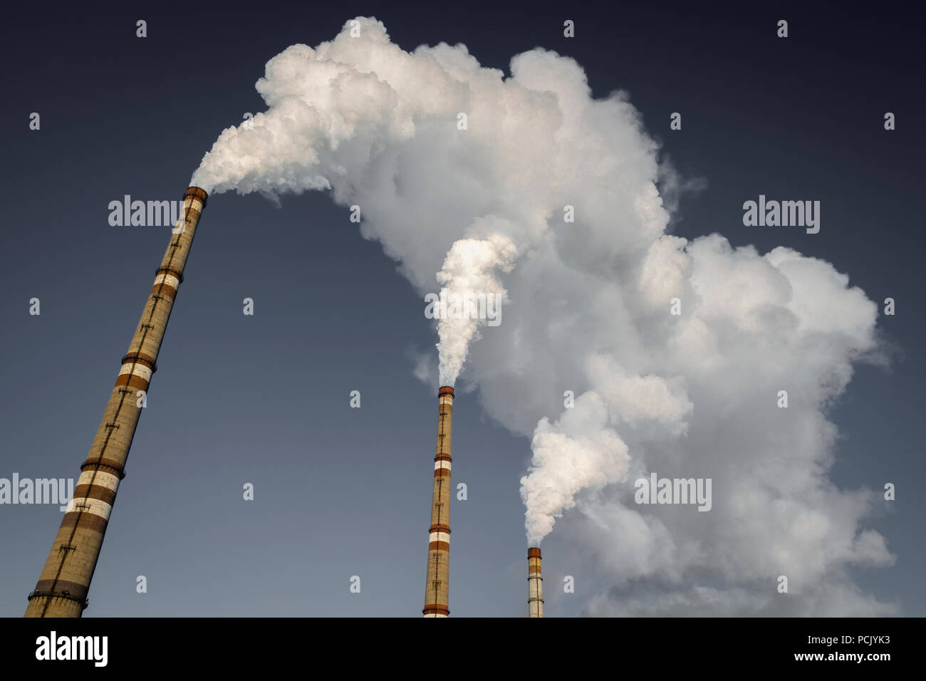 The thick smoke rises high from the industrial pipes. Pollution of the ...