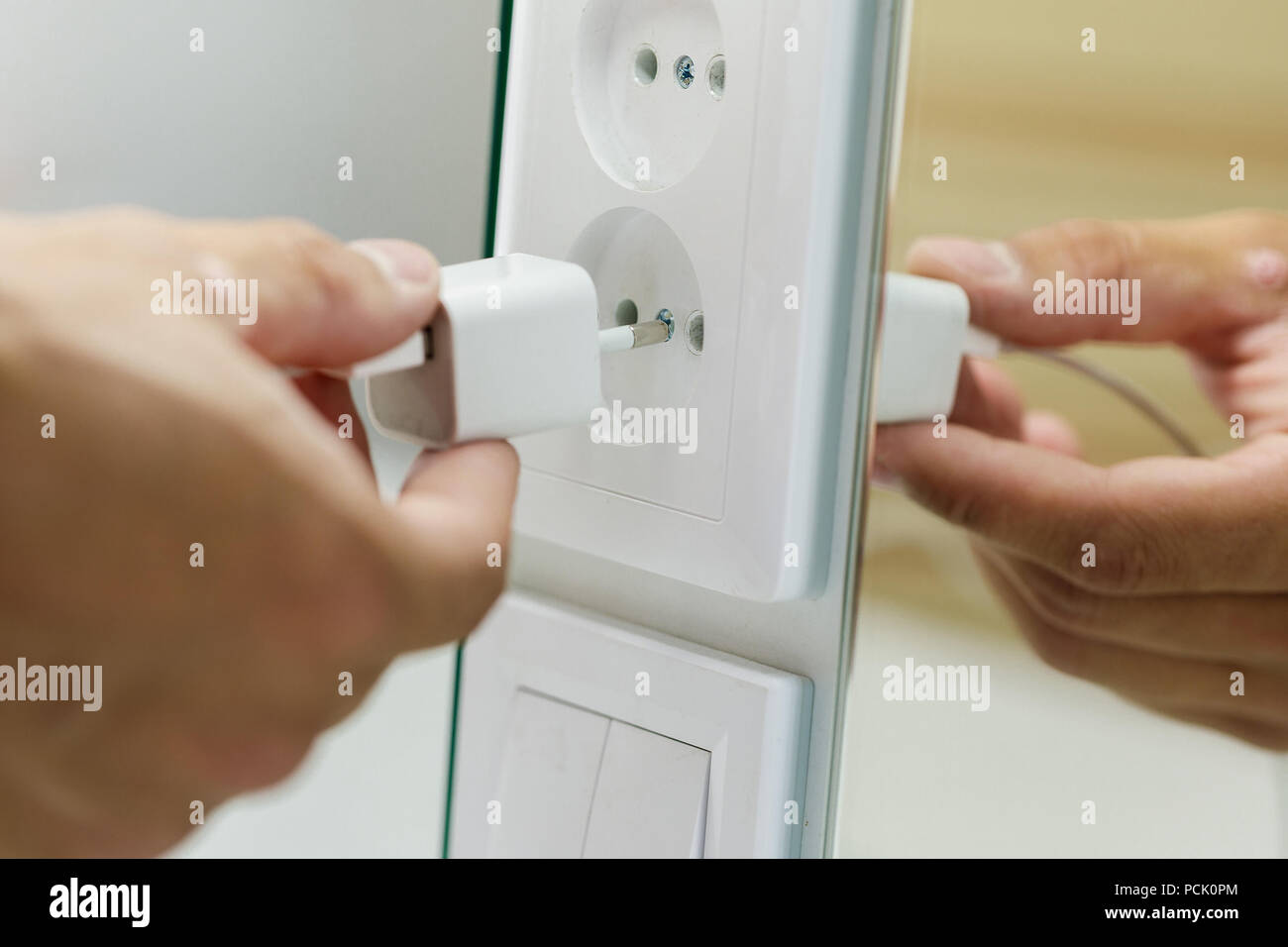 Hand inserting electrical plug into outlet Stock Photo - Alamy