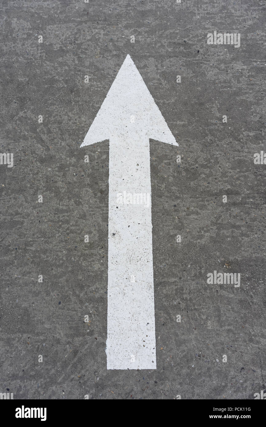 white arrow direction sign on grey concrete Stock Photo - Alamy