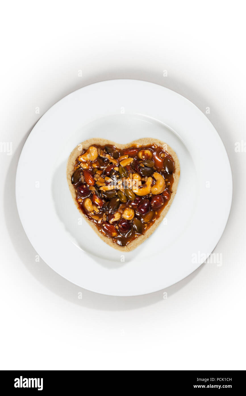 Cute and tasty heart shaped sweet pie on an isolated plate made with ...