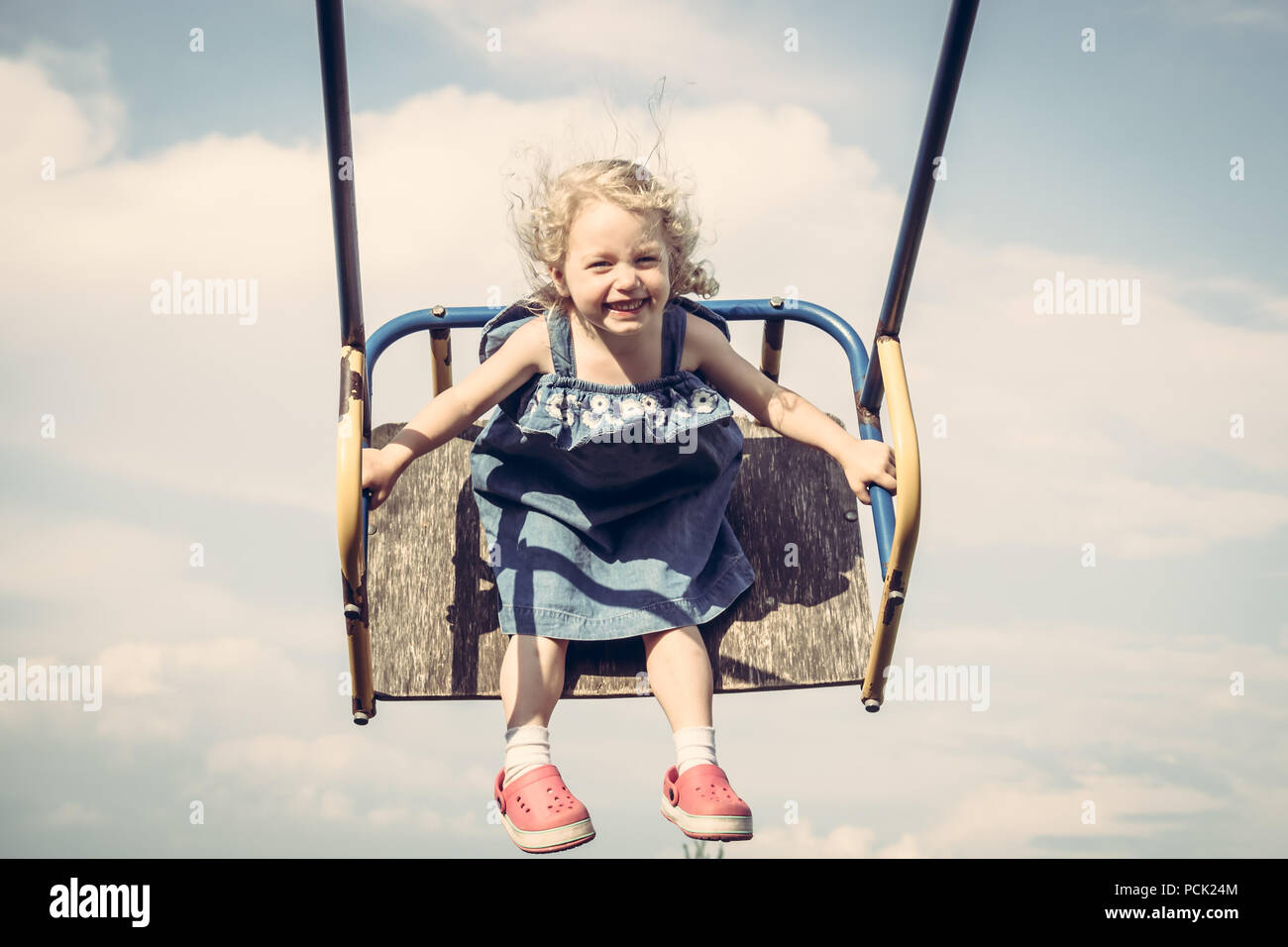 Happy cheerful child girl fun swinging sky happy carefree childhood ...