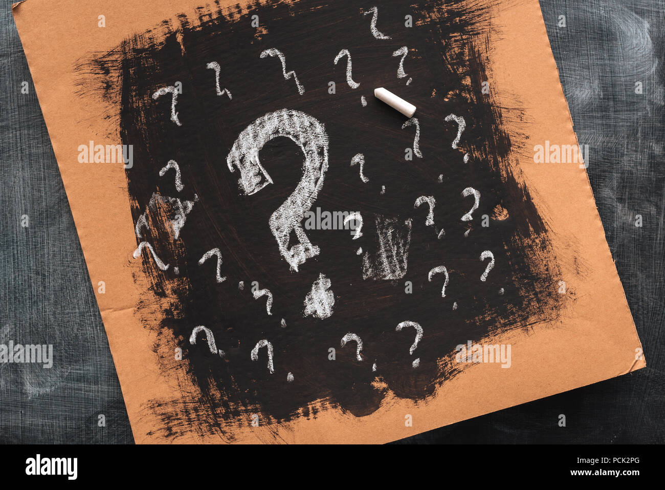 Sketched question marks on cardboard paper, concept of perplex and ...