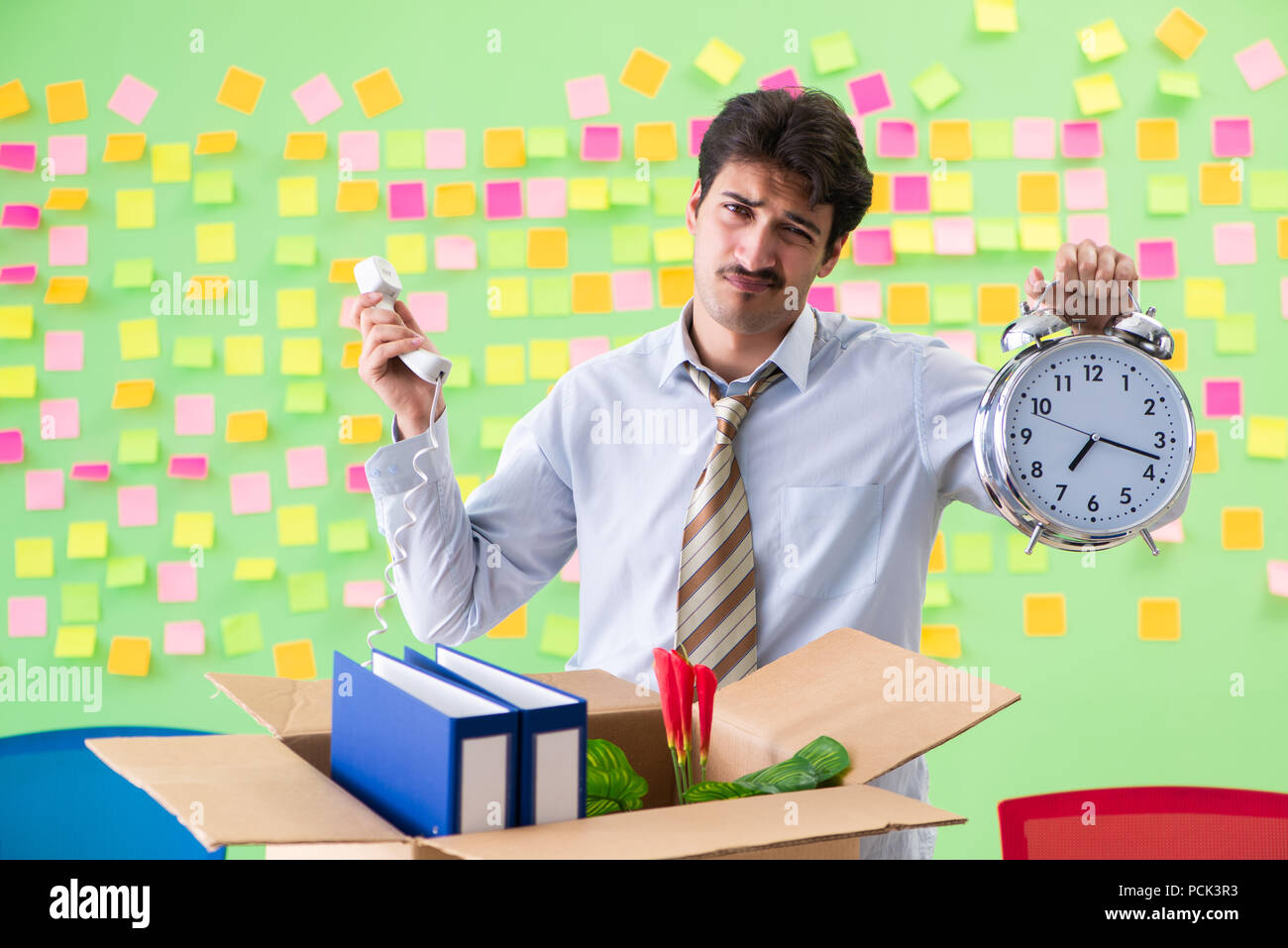 Man collecting his stuff after redundancy in the office with many ...