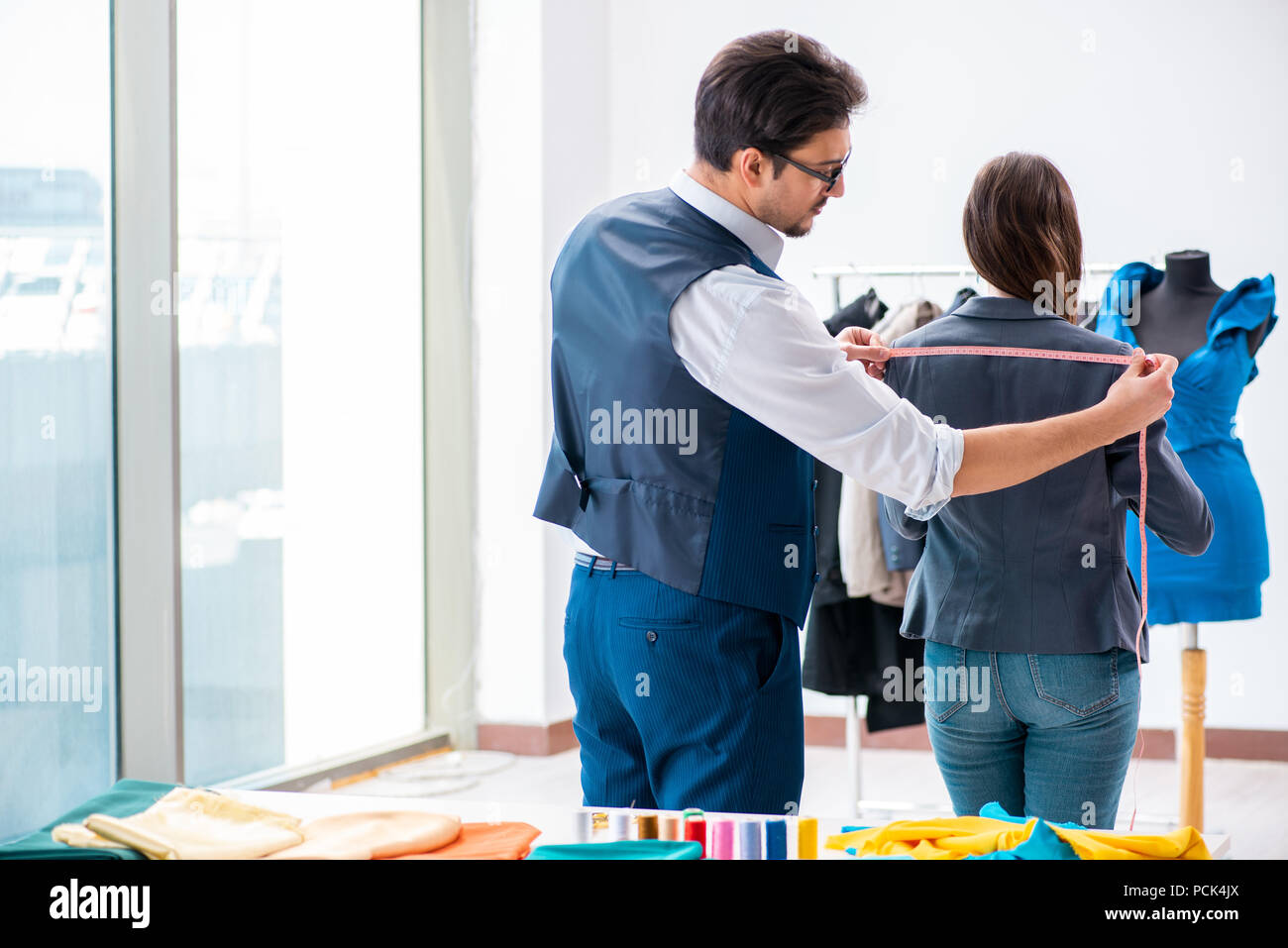 Professional tailor taking measurements for formal suit Stock Photo - Alamy