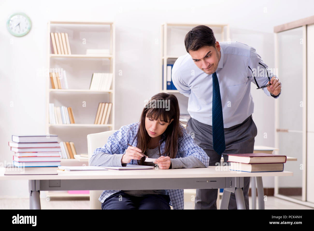 Male lecturer giving lecture to female student Stock Photo - Alamy