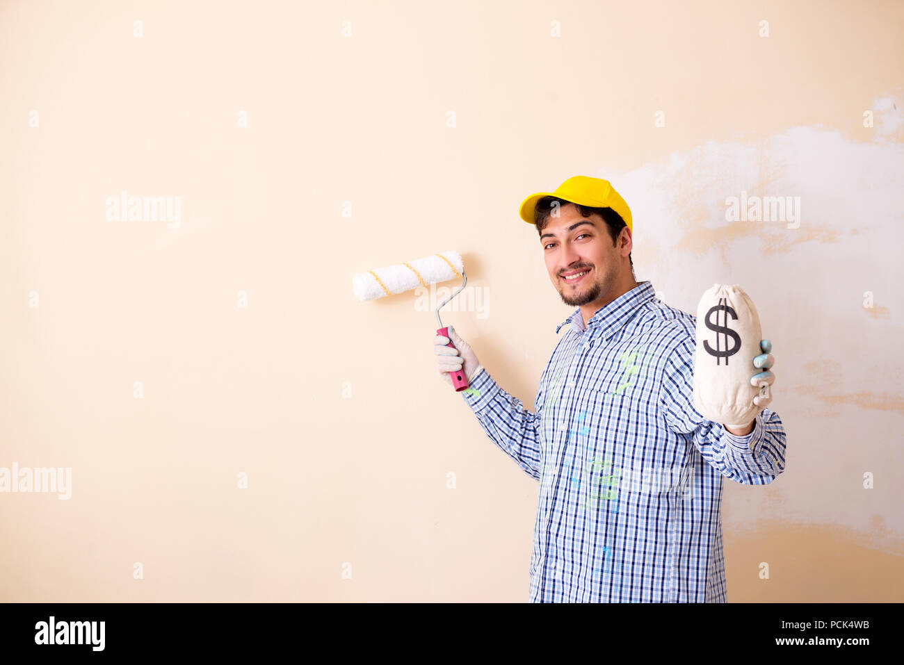 Painter man painting the wall at home Stock Photo - Alamy