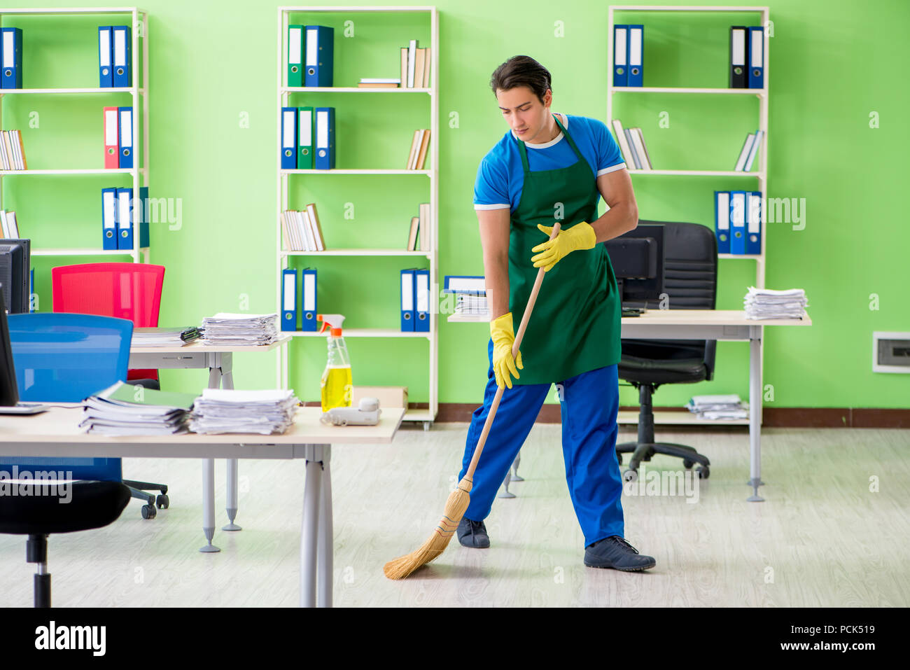 Young male handsome professional cleaner cleaning floor with broom ...