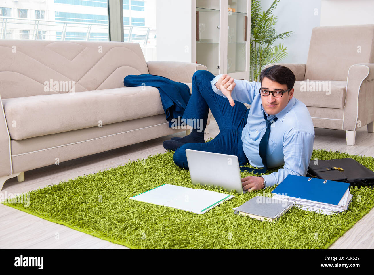 Businessman taking work home and working overtime Stock Photo - Alamy