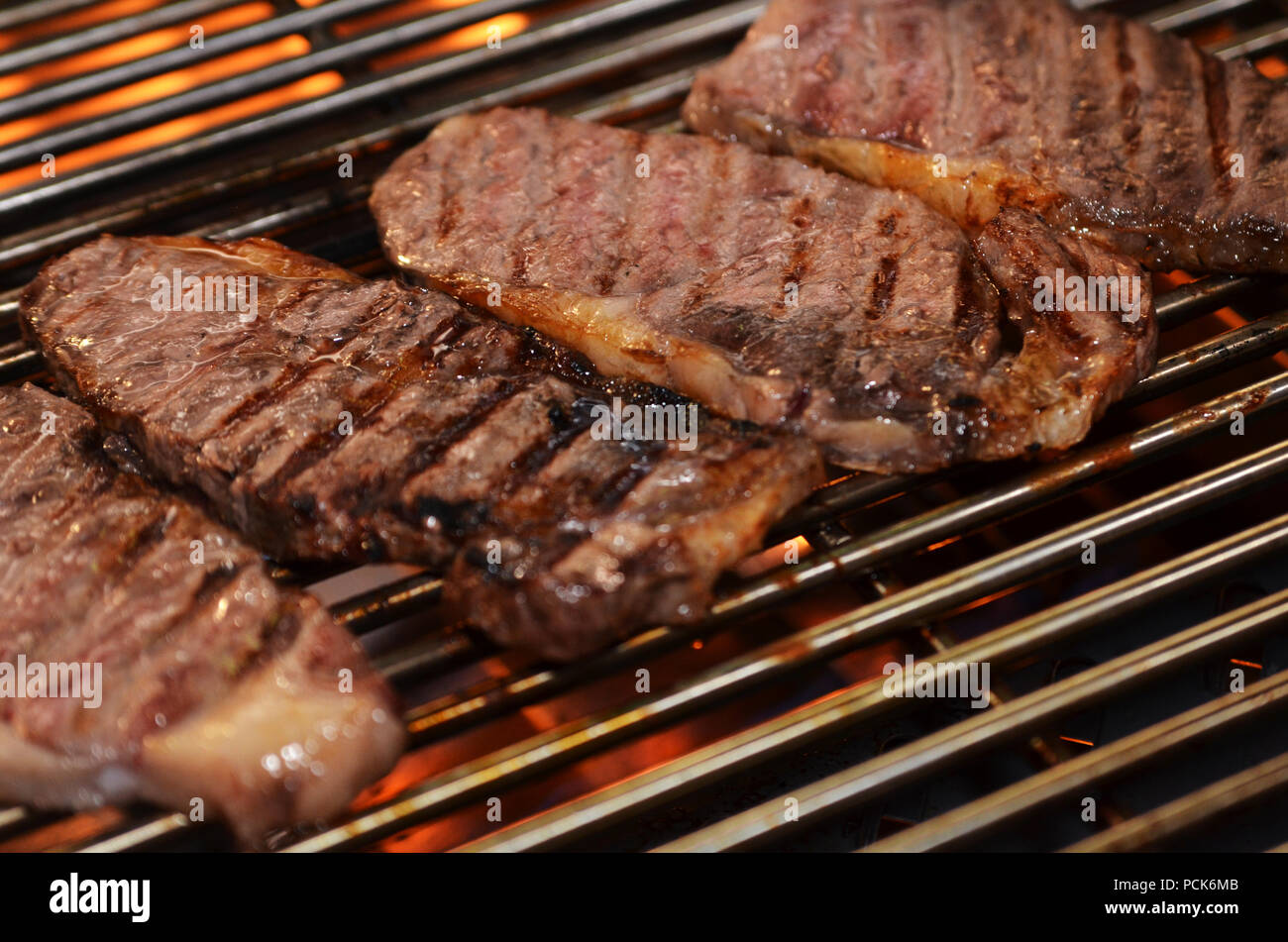 Beef steaks on the grill with flames Stock Photo - Alamy