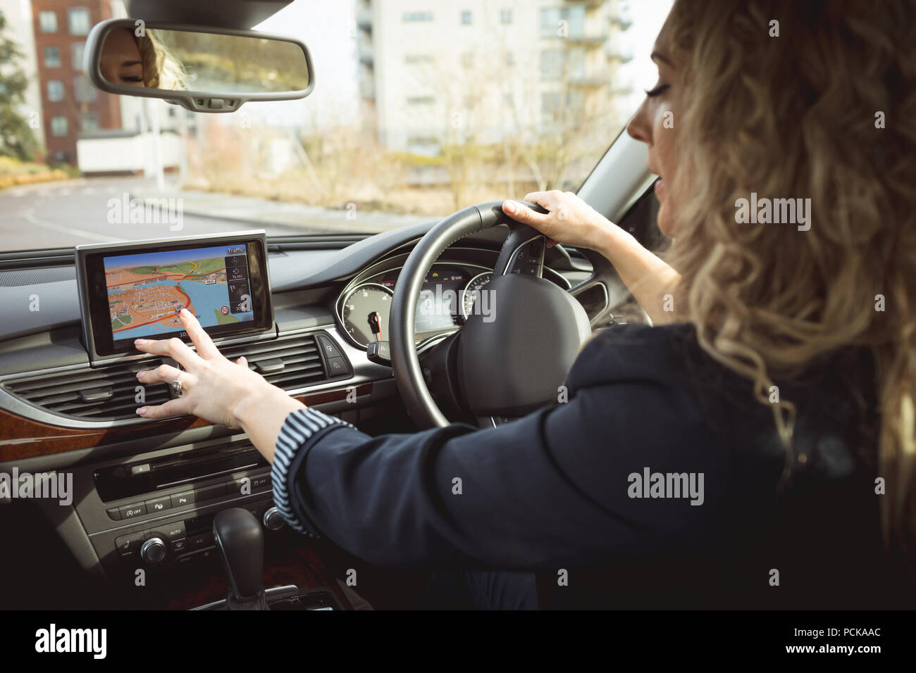 Female executive using navigation while driving a car Stock Photo - Alamy