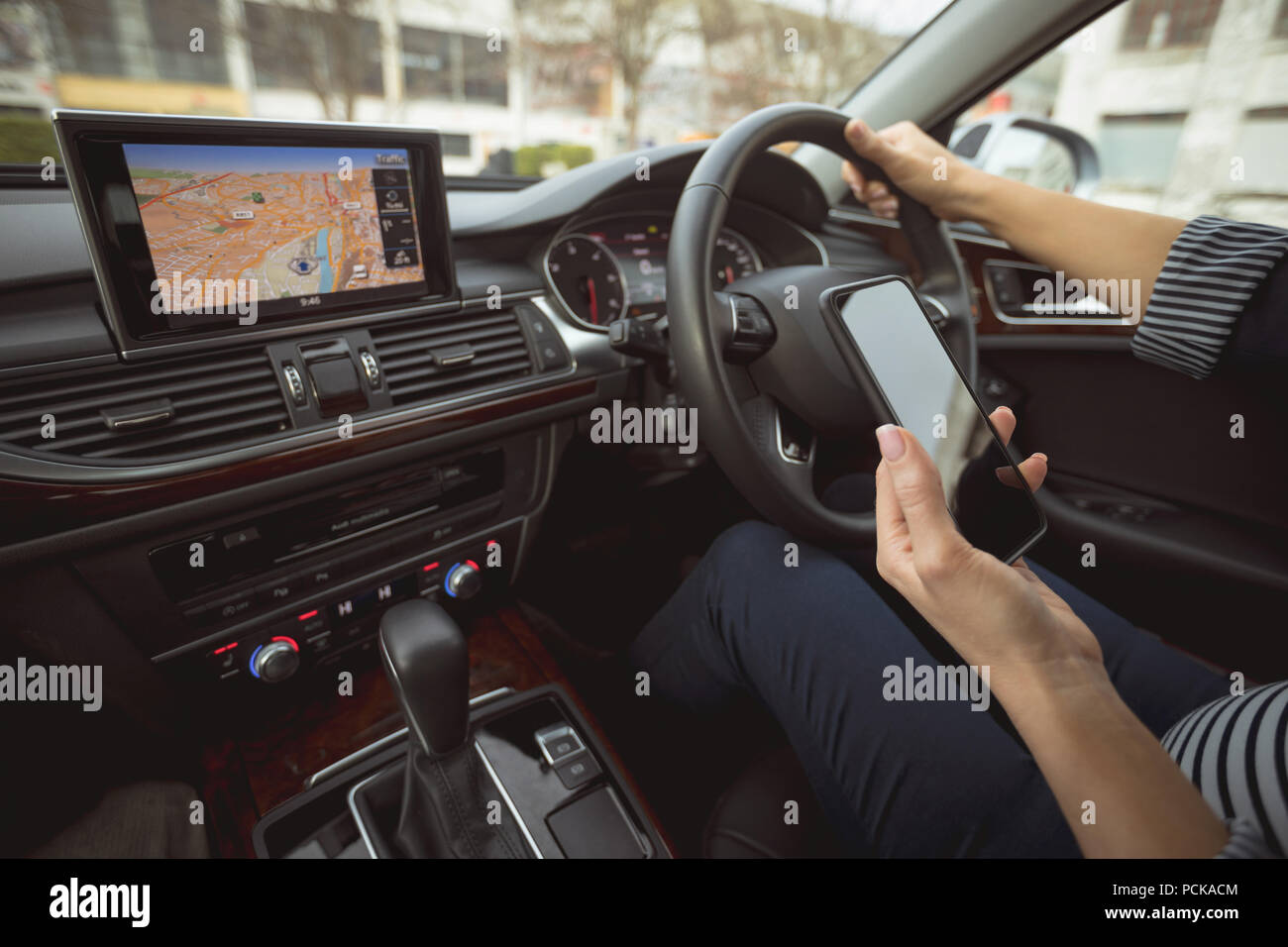 Female executive using mobile phone while driving a car Stock Photo - Alamy