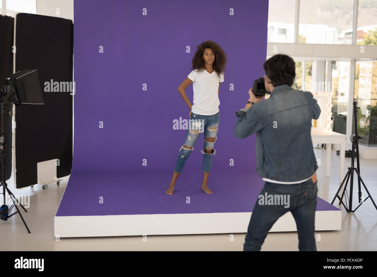 Photographer taking picture of model in studio Stock Photo - Alamy