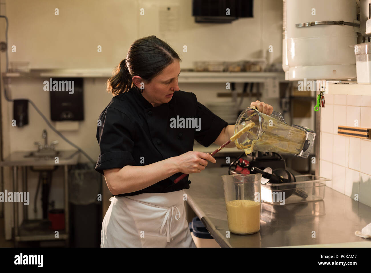 Chef emptying a ground paste in a container Stock Photo - Alamy