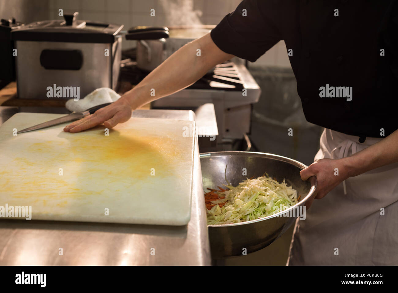 Chef putting chopped vegetables into the big bowl Stock Photo - Alamy