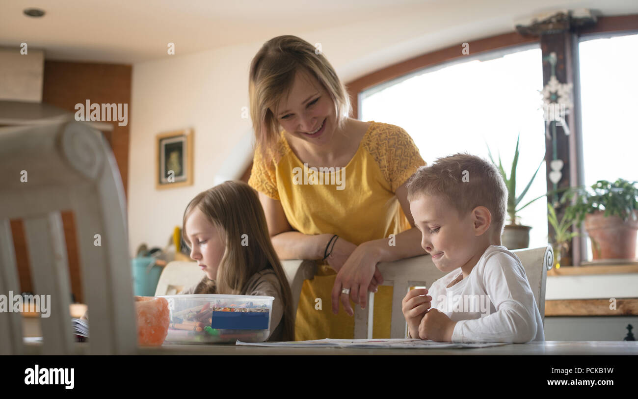 Mother helping children with homework in kitchen Stock Photo - Alamy