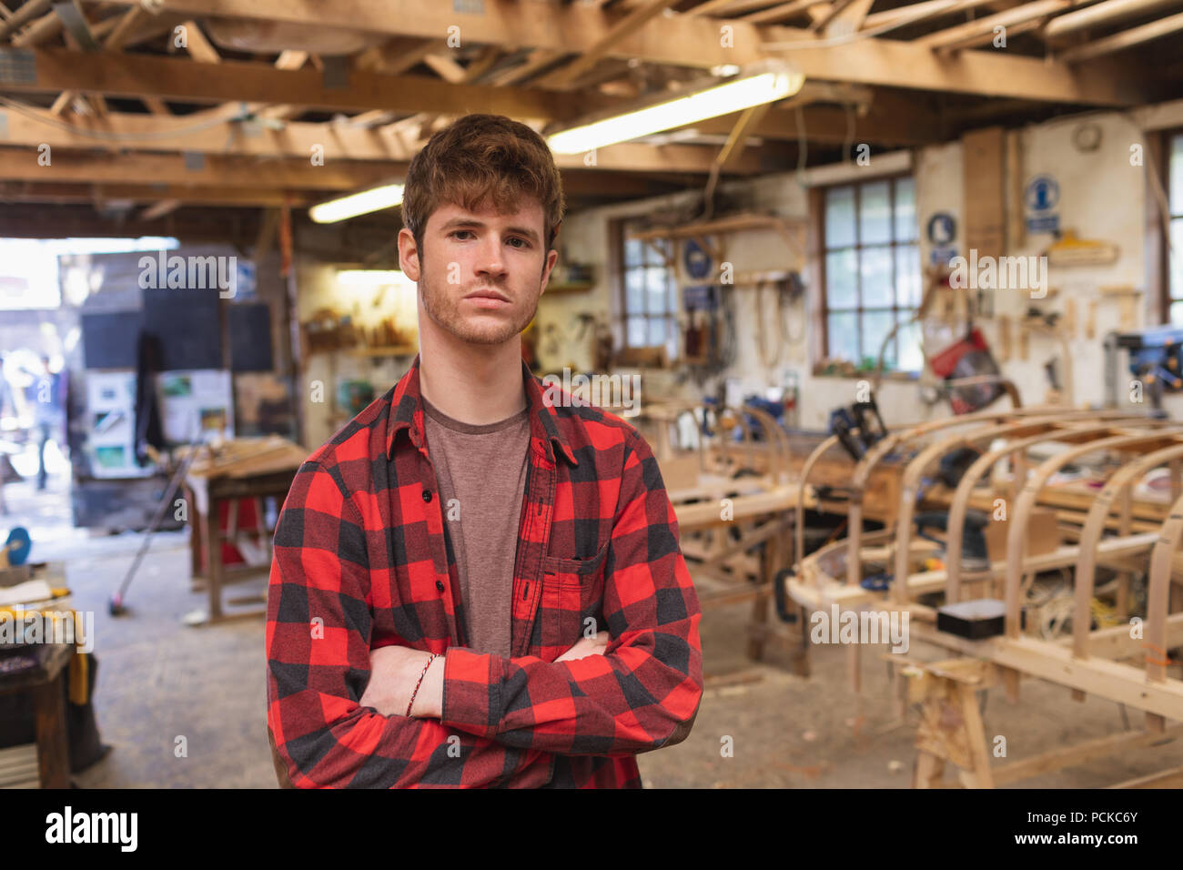 Male carpenter standing with arms crossed Stock Photo - Alamy