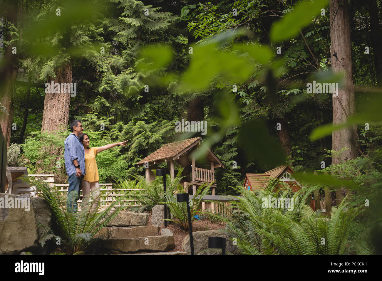Woman pointing at distance in the garden Stock Photo - Alamy