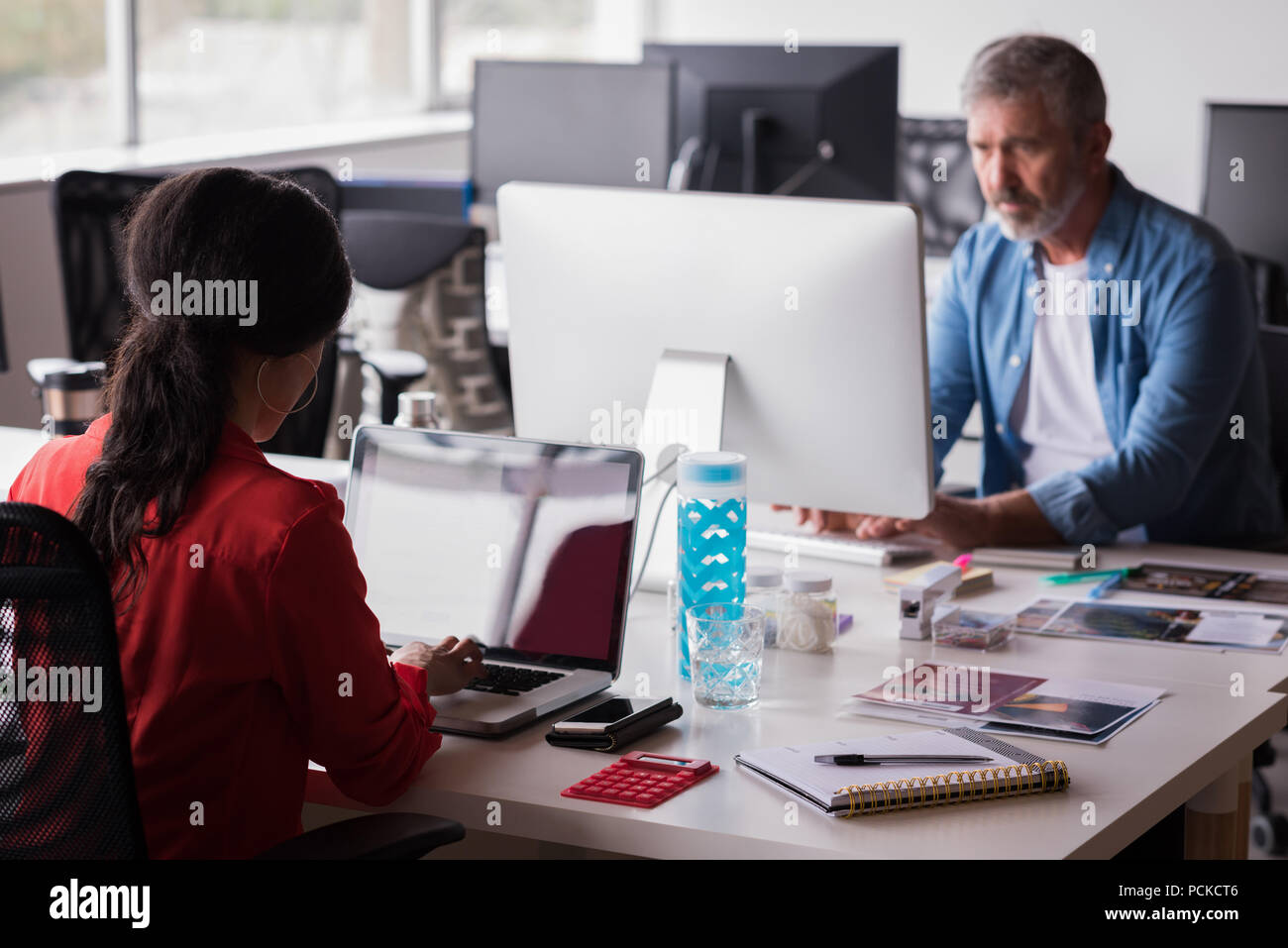 Office colleagues working on desk Stock Photo - Alamy
