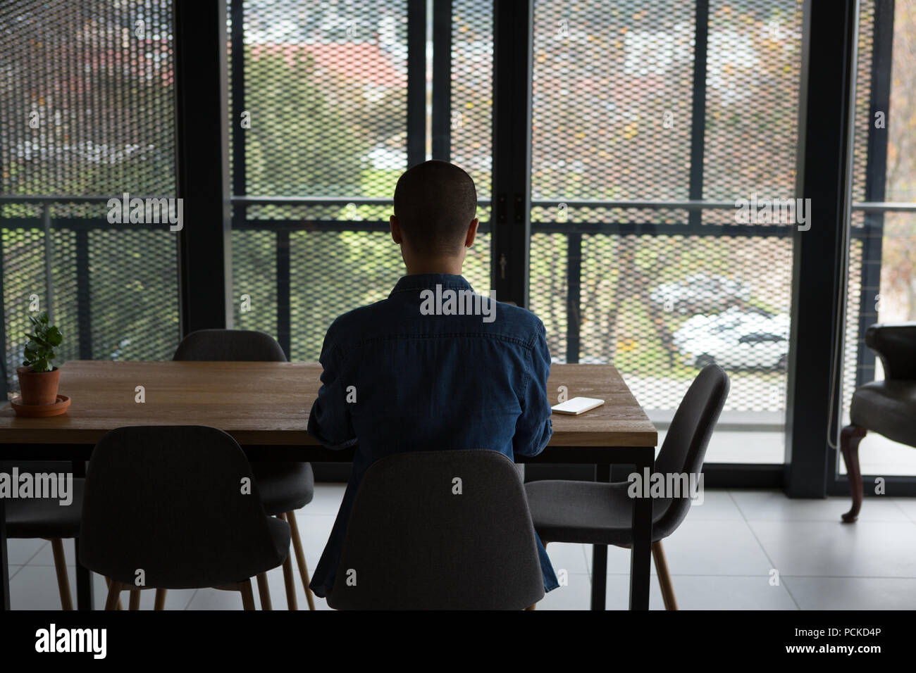 Man sitting on chair at home Stock Photo - Alamy