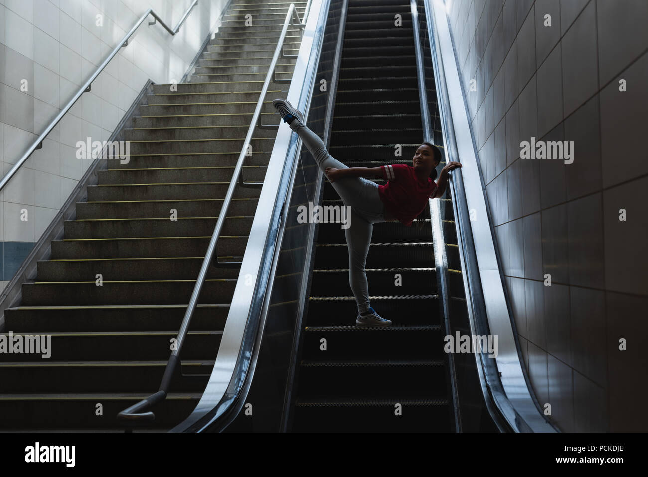 Female street dancer dancing on escalator Stock Photo - Alamy