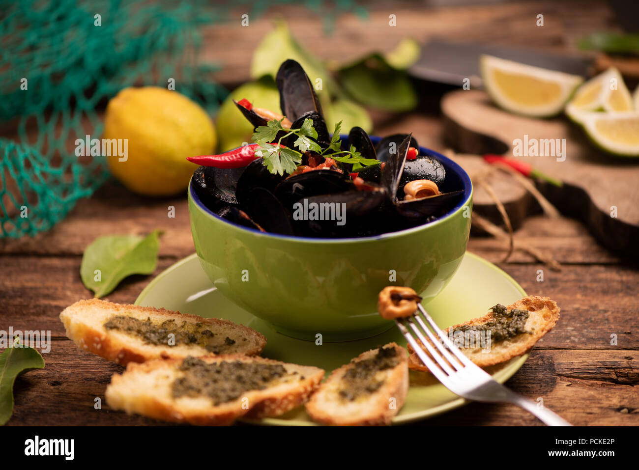 Boiled mussels in cooking dish on wooden background Stock Photo - Alamy