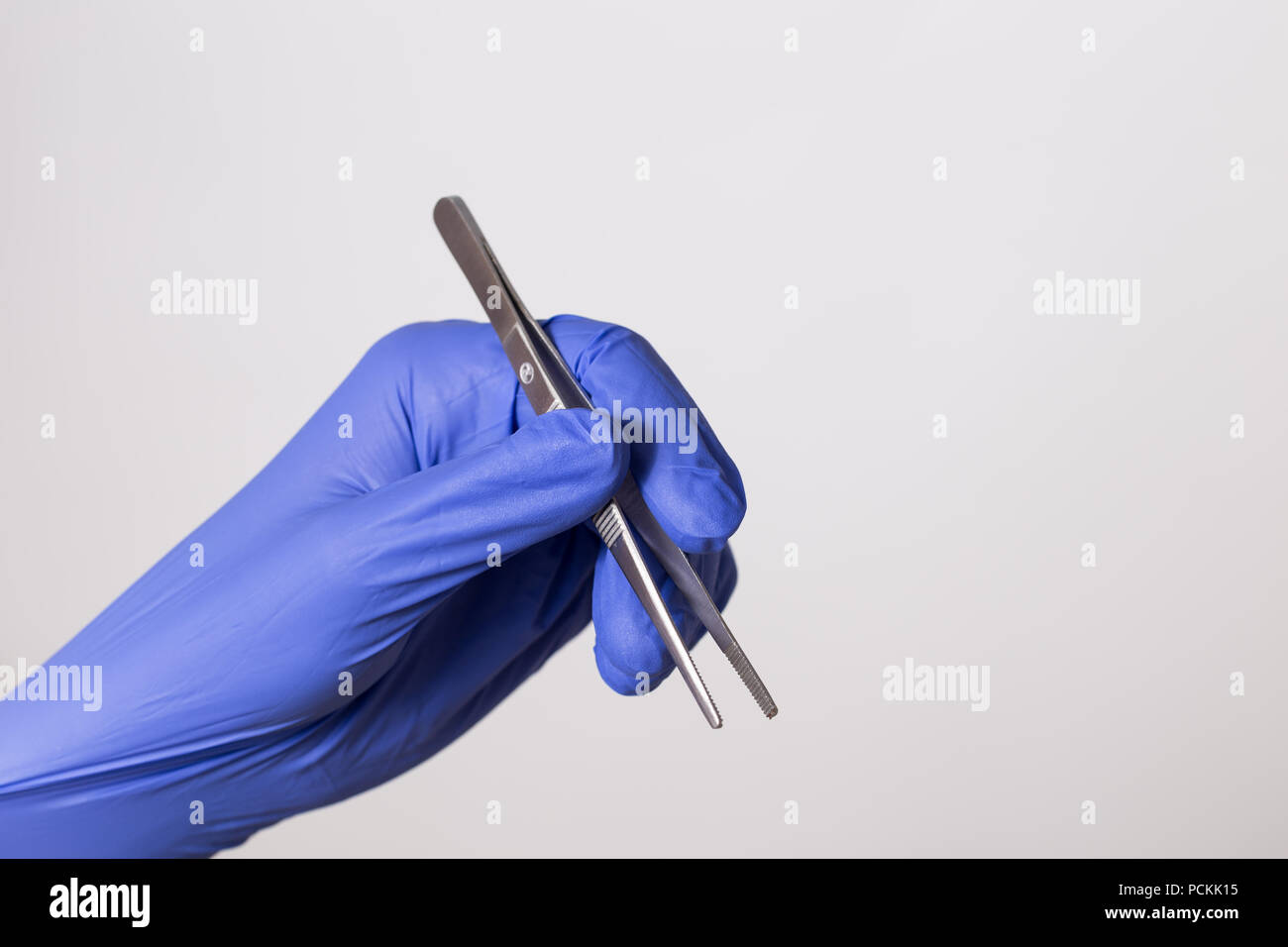 hand in gloves hold tweezer Stock Photo - Alamy