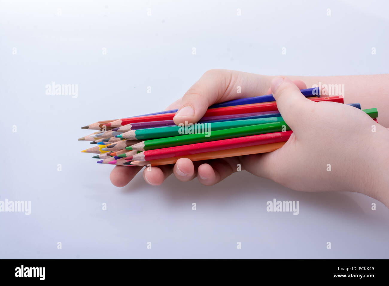 Hand holding color Pencils placed on a white background Stock Photo - Alamy