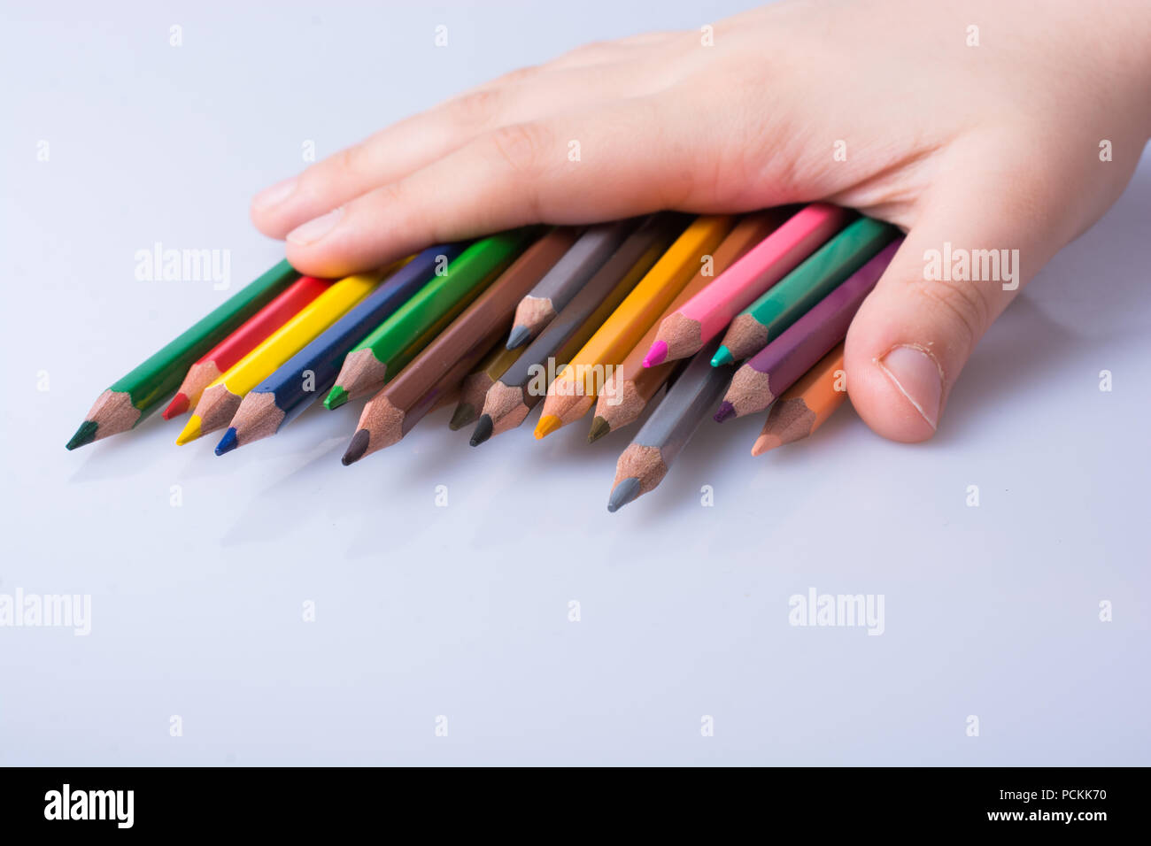 Hand holding color Pencils placed on a white background Stock Photo - Alamy