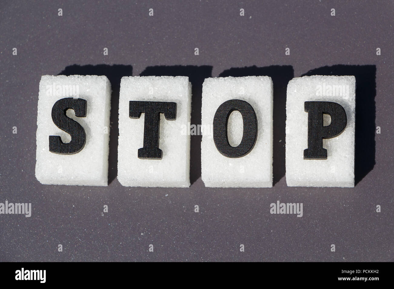 Stop written in black wooden letters on sugar cube Stock Photo - Alamy