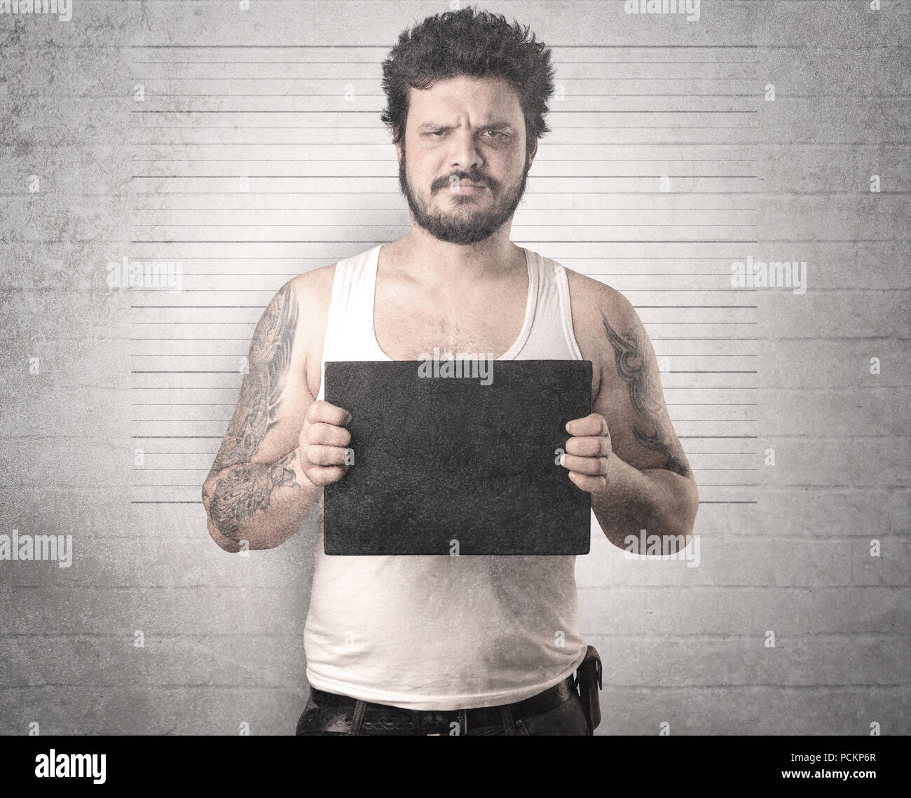Gangster in front of a wall with table on his hand Stock Photo - Alamy