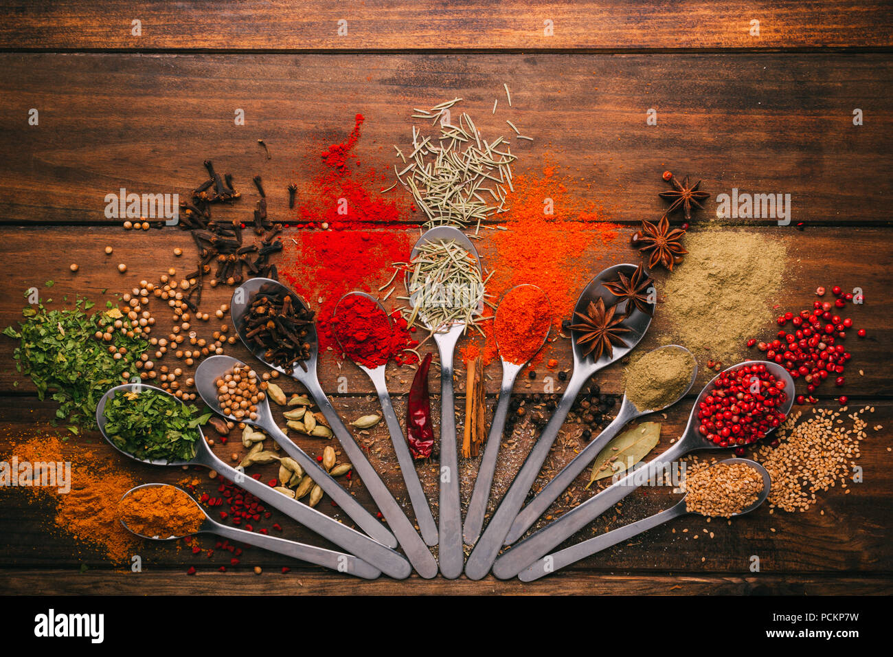 Top view of wooden table full of spices in spoons, you can see the most ...