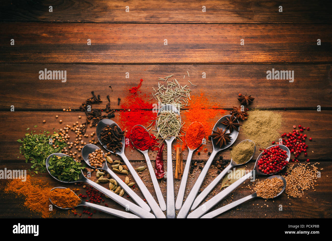 Top view of wooden table full of spices in spoons, you can see the most ...