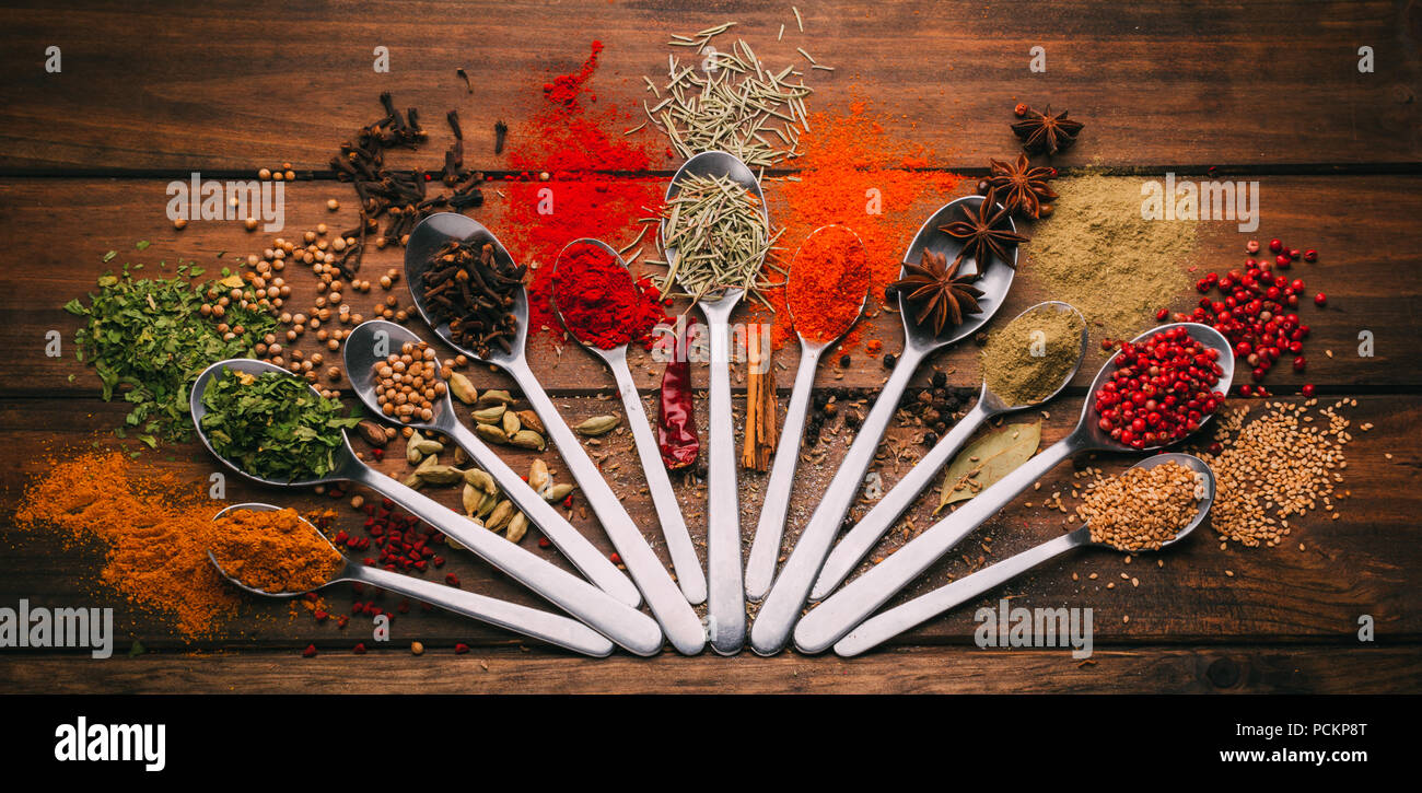 Top view of wooden table full of spices in spoons, you can see the most ...
