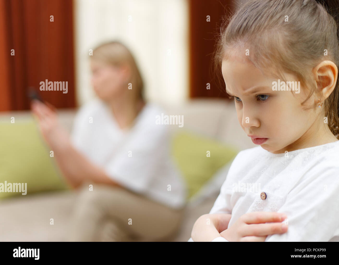 Sadness young girl. Portrait of bored daughter with mother using ...