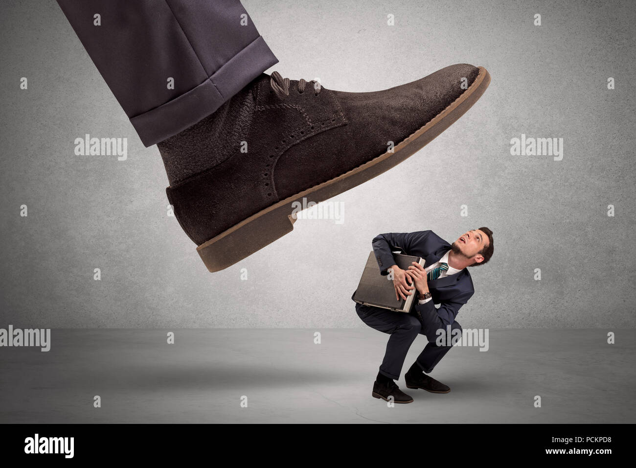 Employee is afraid of the big boss foot, which is stepping down him ...