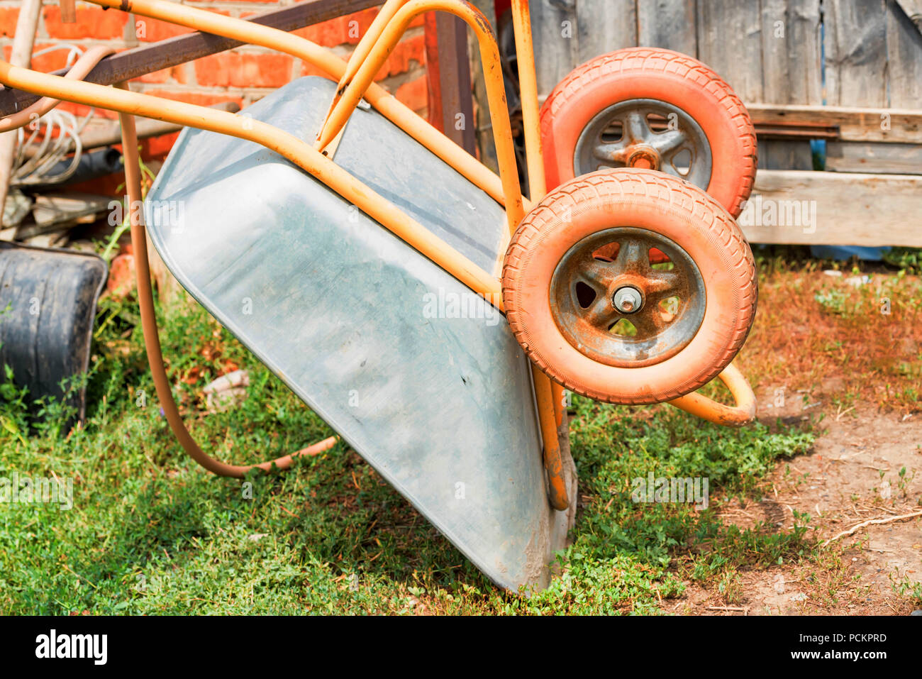 Old rusty wheelbarrow cart in the garden Stock Photo - Alamy