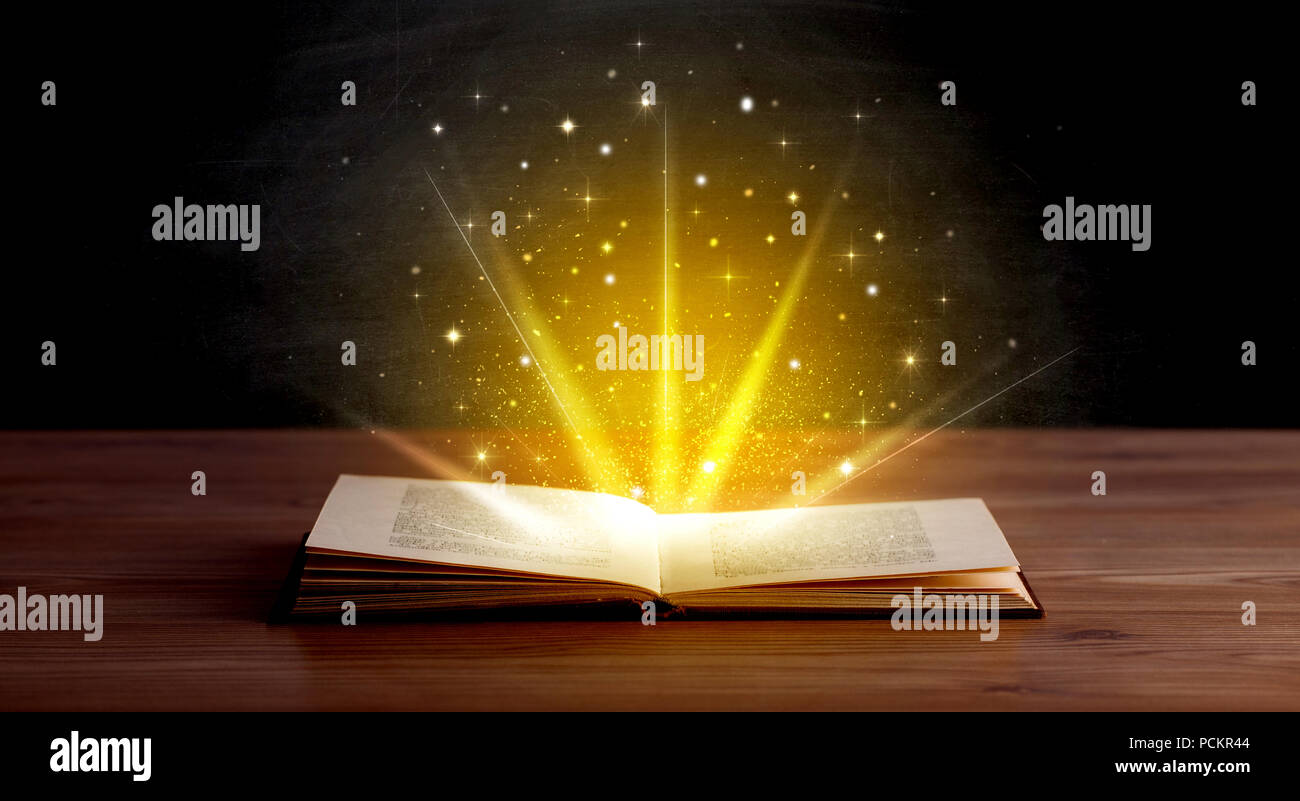 Yellow lights and sparkles coming from an open book Stock Photo - Alamy