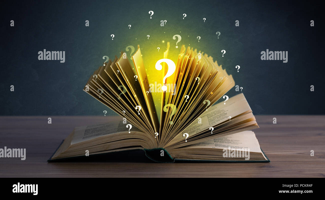 Yellow question marks hovering over open book Stock Photo - Alamy