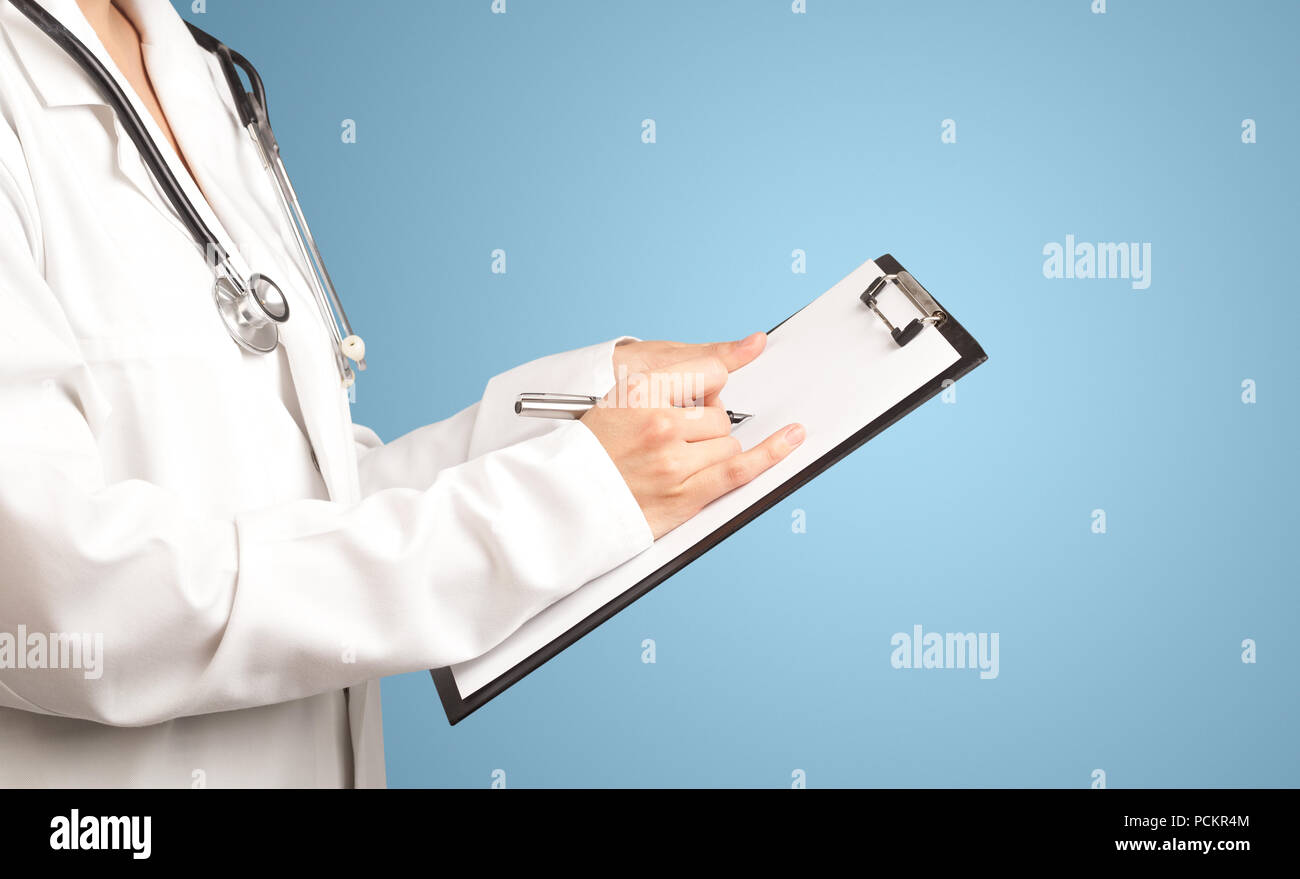 Female doctor holding notepad with blue background Stock Photo - Alamy