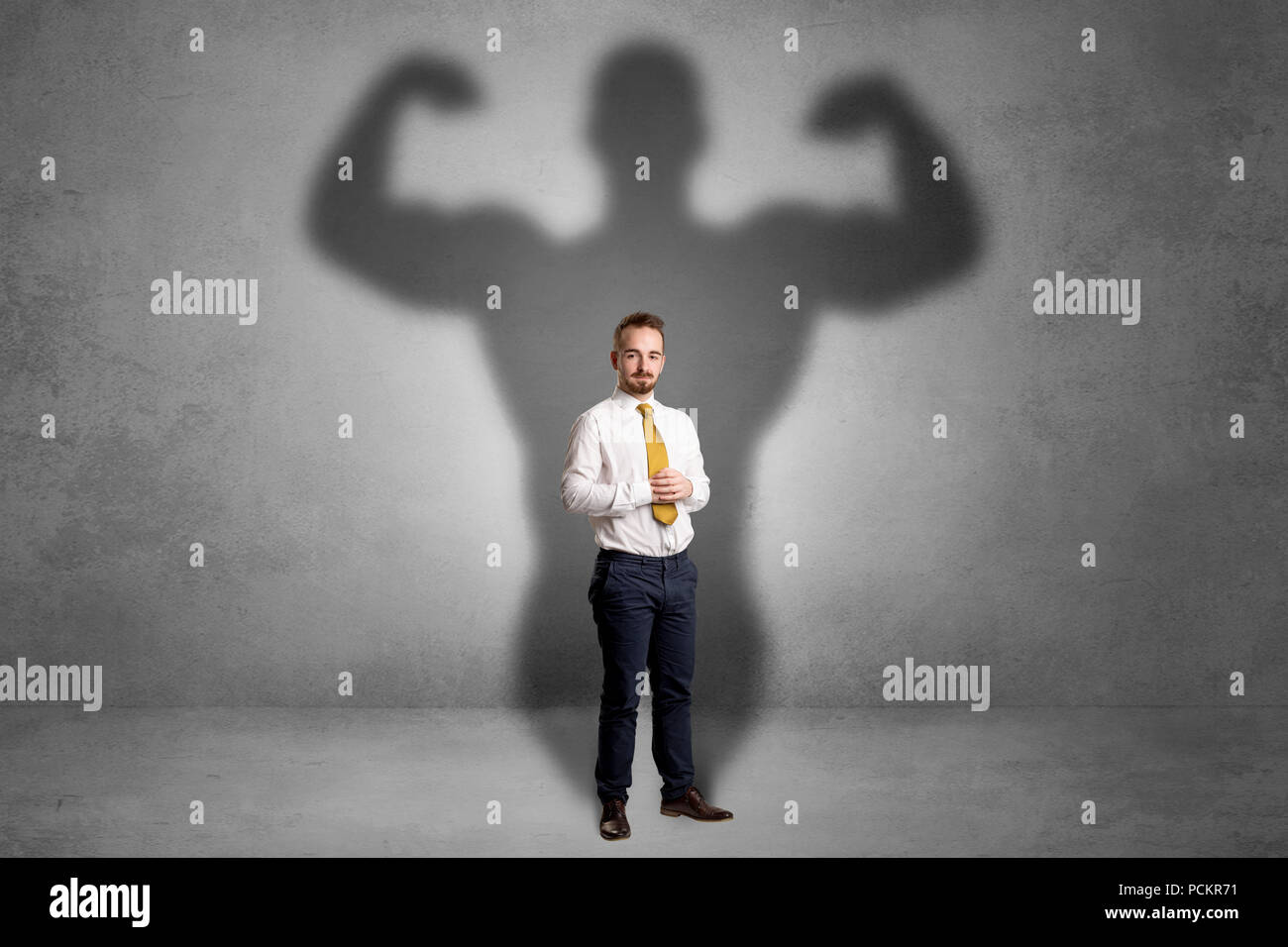 Lovely serious businessman standing with a muscular powerful shadow ...
