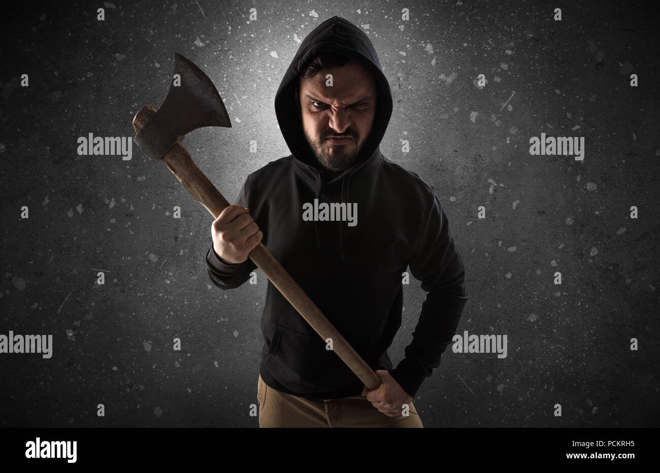 Masked armed villain in empty dark room with gun ax chainsaw mallet ...