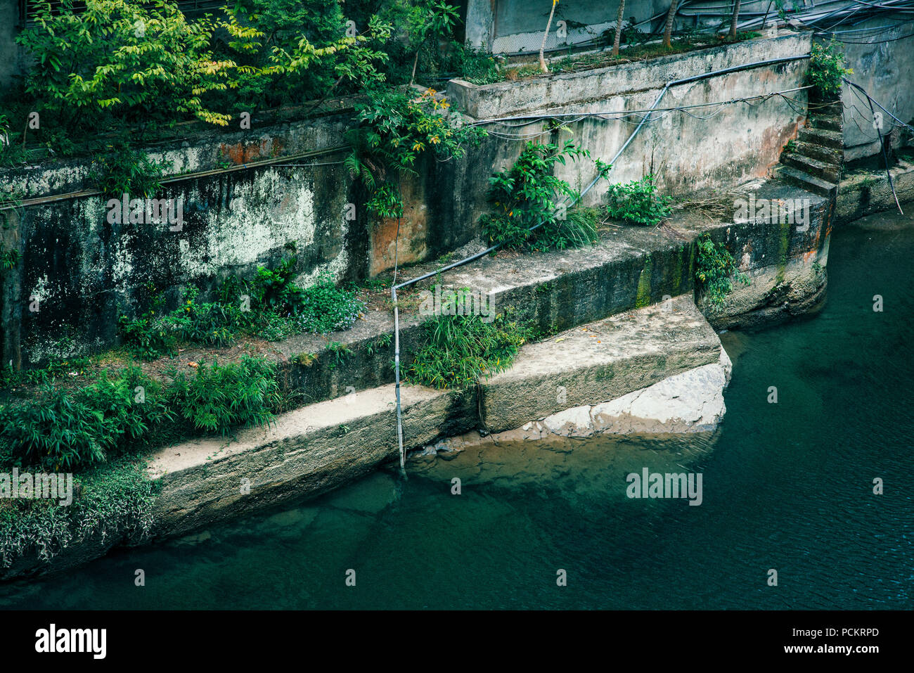 Section of riverbank in rural area with stairs and pipes Stock Photo ...
