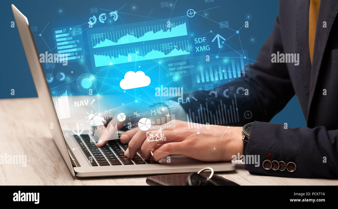 Businessman hand typing on laptop with reports and graphs concept ...