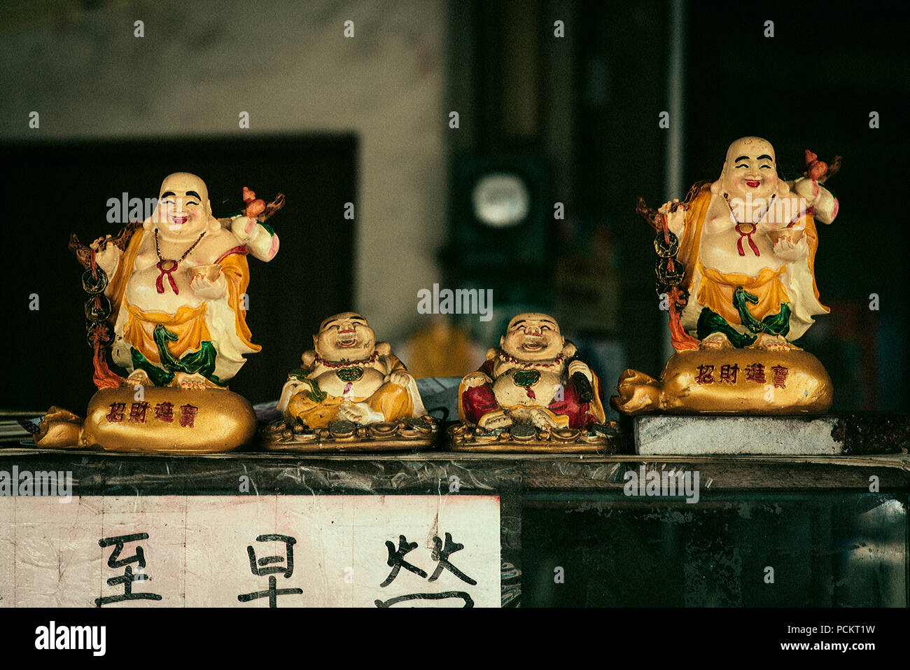 Smiling Buddha statues on display in shop window Stock Photo - Alamy