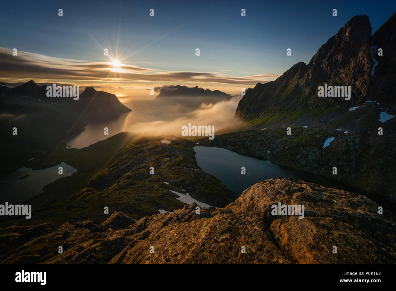 Breidtinden summit over cloudy Mefjorden and two lakes in sunset light ...