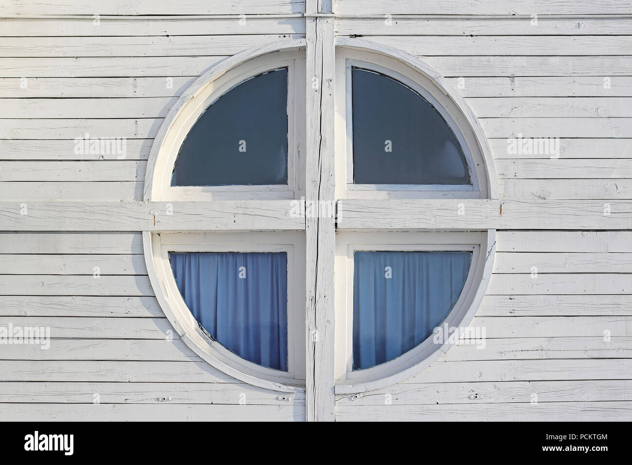 Round window at white wood cabin house Stock Photo - Alamy
