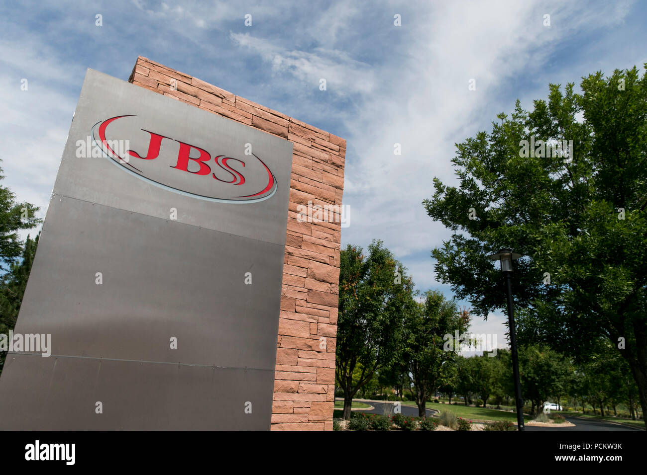 A logo sign outside of the headquarters of JBS USA Holdings, Inc., in ...