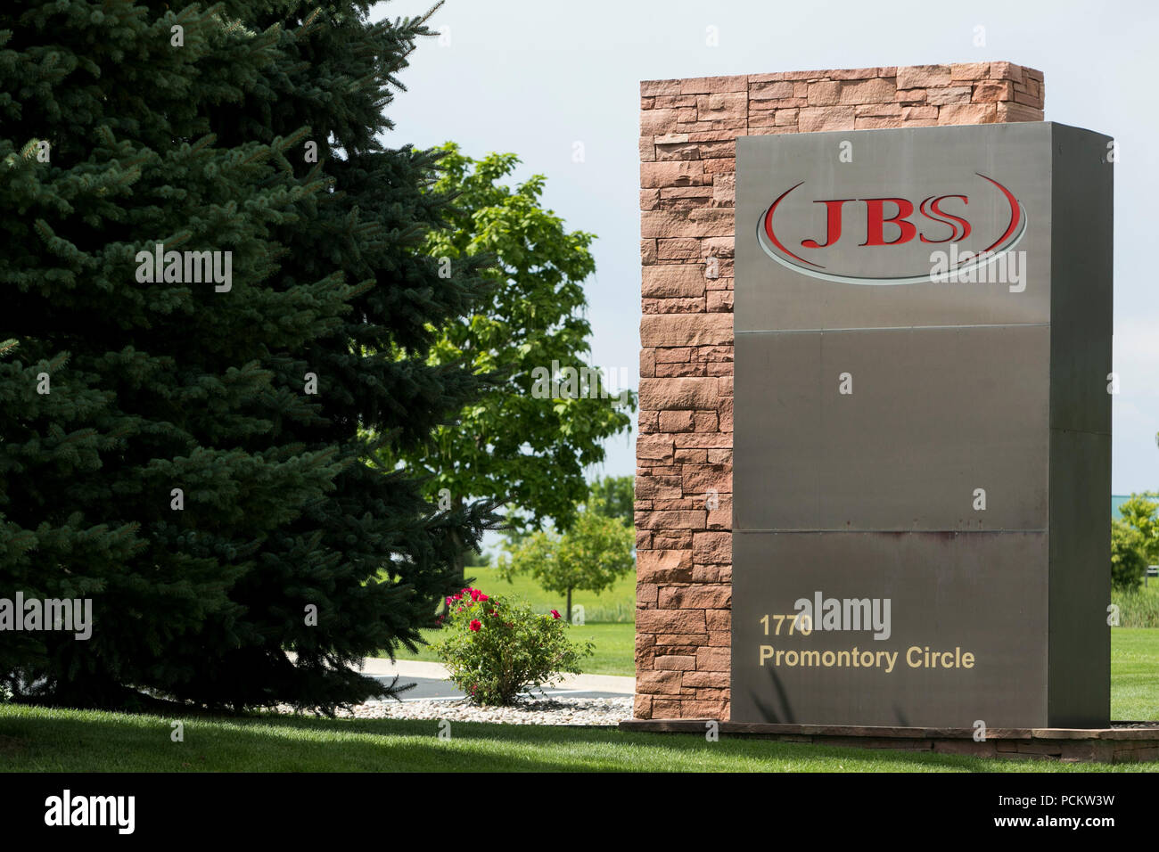 A logo sign outside of the headquarters of JBS USA Holdings, Inc., in ...