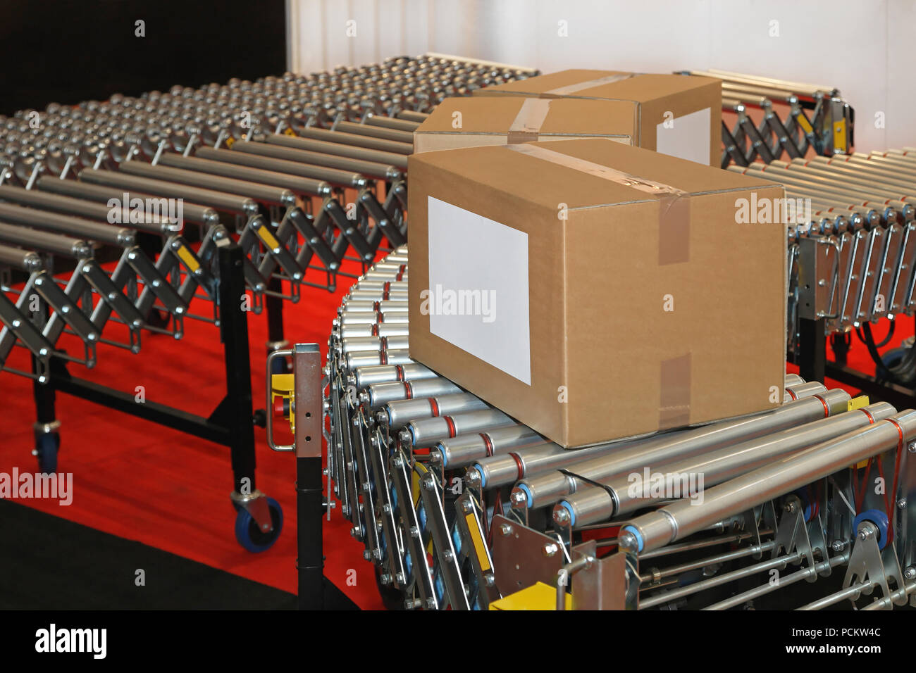 Powered conveyor rollers for box transfer in factory Stock Photo - Alamy