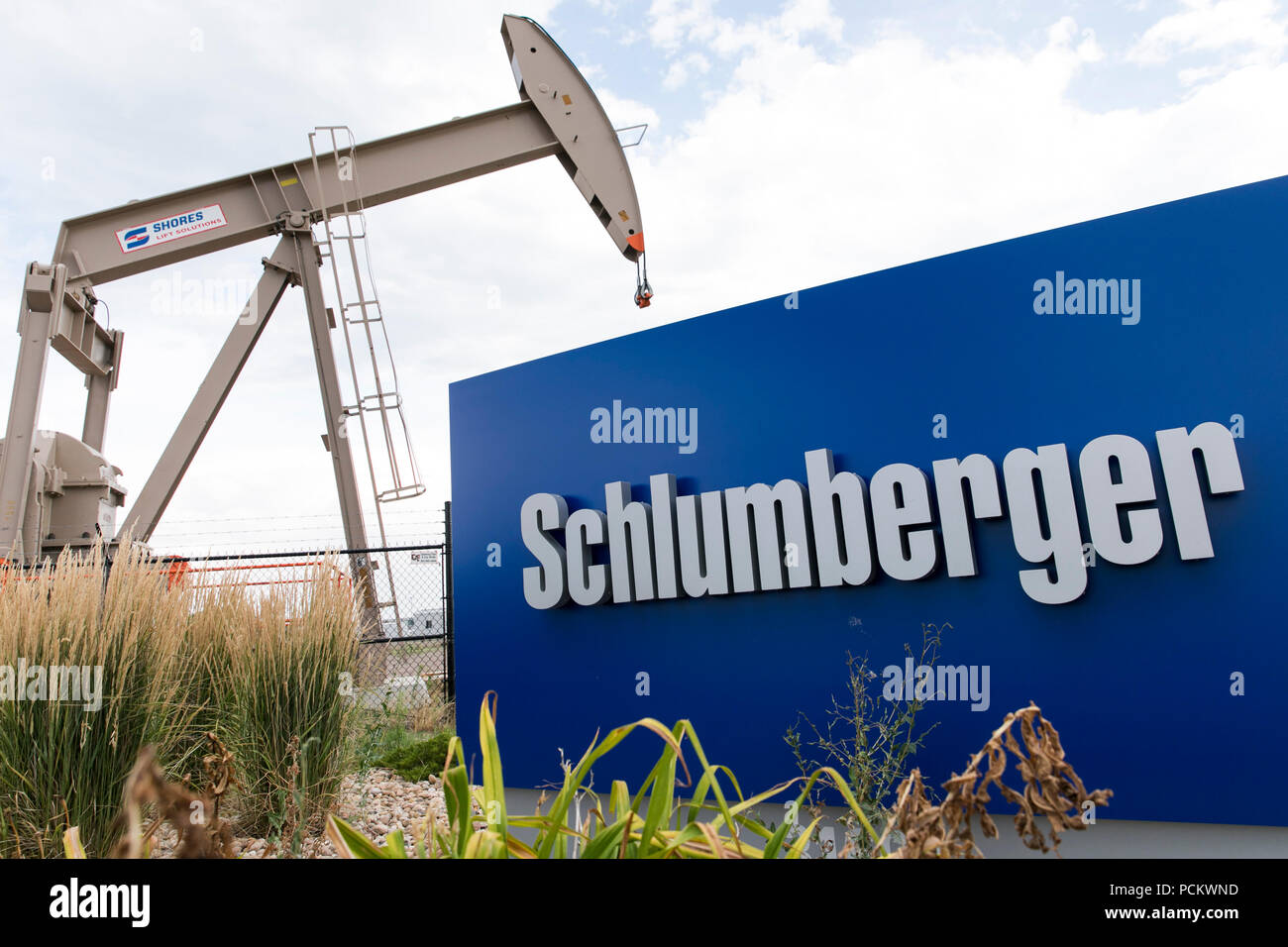 A logo sign and oil pump outside of a facility occupied by Schlumberger ...